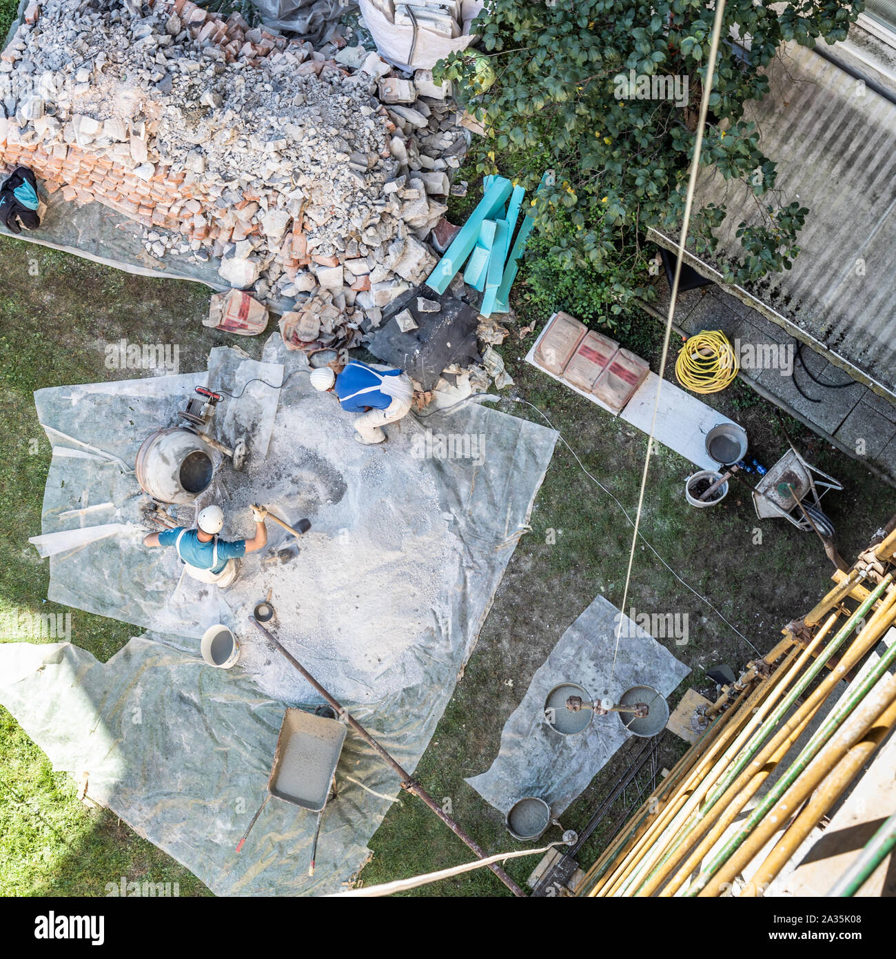 Top view of authentic builder men working with shovel during concrete ...
