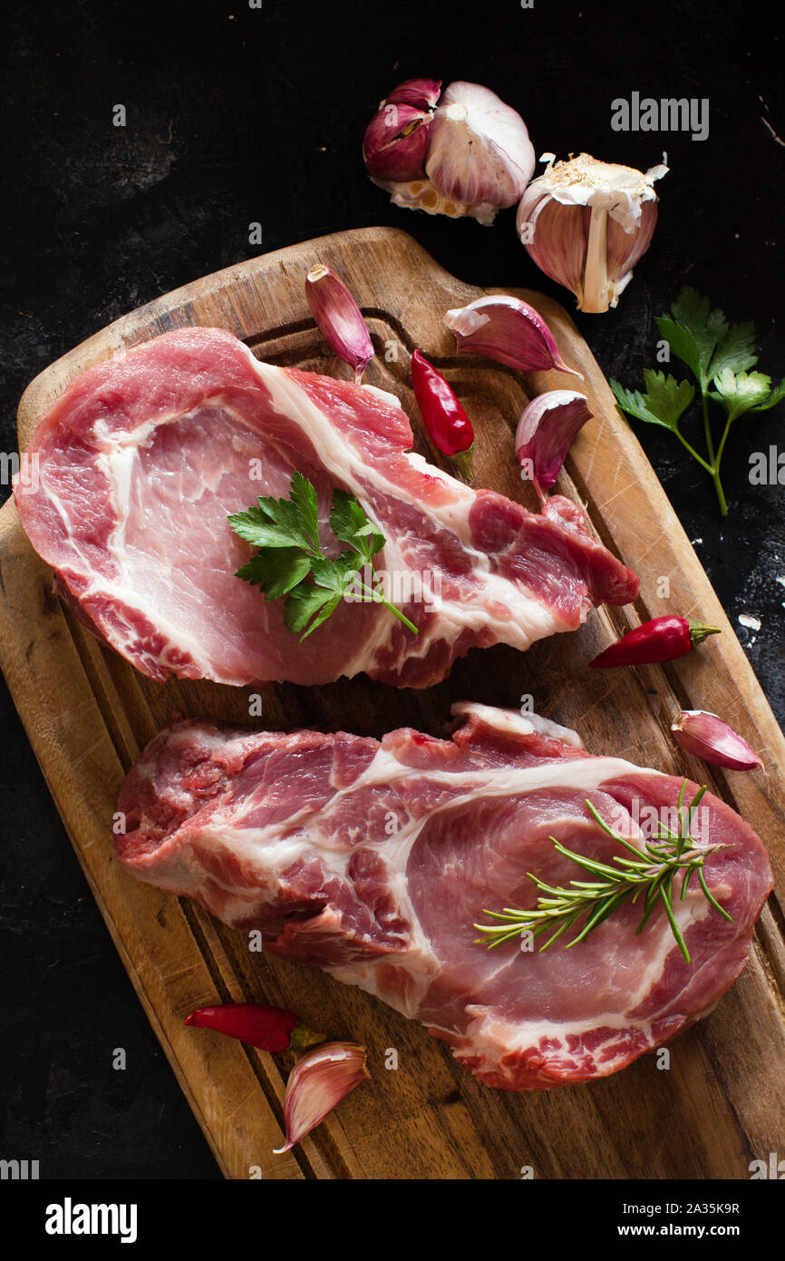 Raw pork steaks called capicola with vegetables and herbs Stock Photo ...