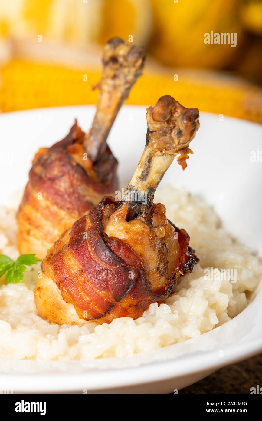 chicken legs with bacon on risotto Stock Photo - Alamy