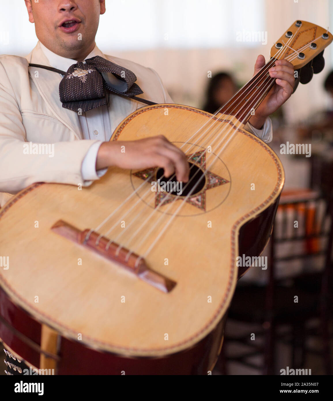 photo of mariachi man wearing traditional outfit and holding guitar ...
