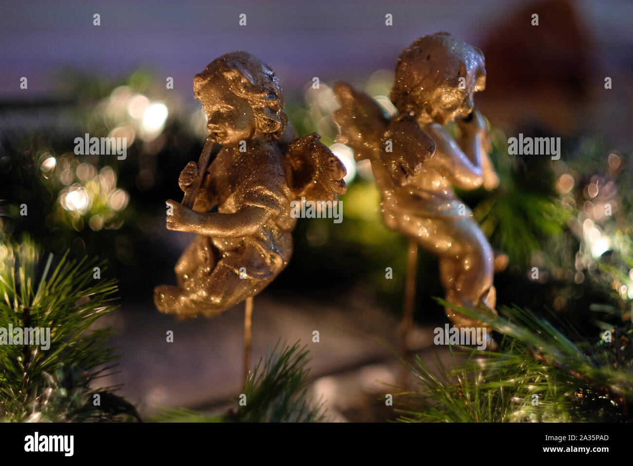 Two golden figures of angels in the light of the illumination for ...