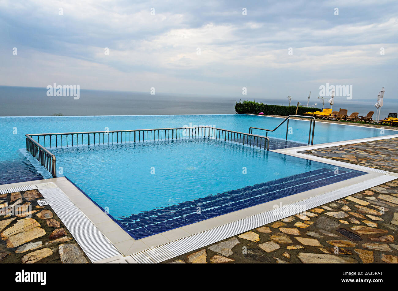 Infinity pool with crystal blue water view to sea ocean Stock Photo - Alamy