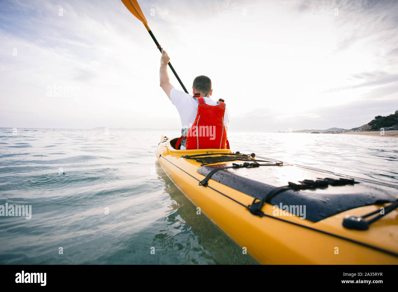 Rear view of man paddling kayak Stock Photo - Alamy
