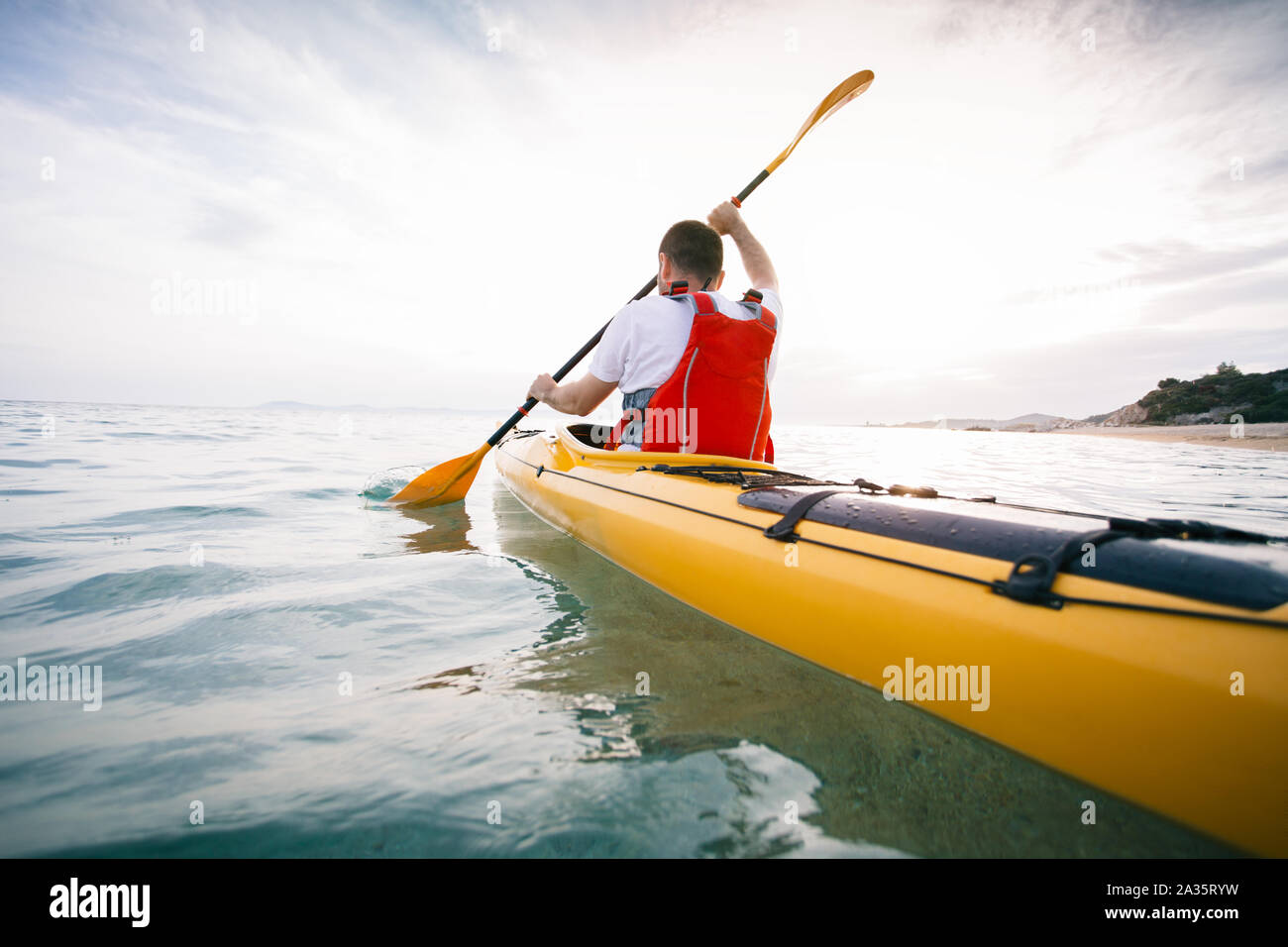 Rear view of man paddling kayak Stock Photo - Alamy