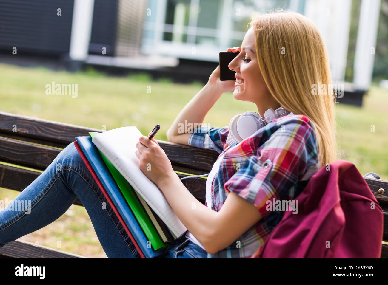 Female student studying and using mobile phone outdoor Stock Photo - Alamy