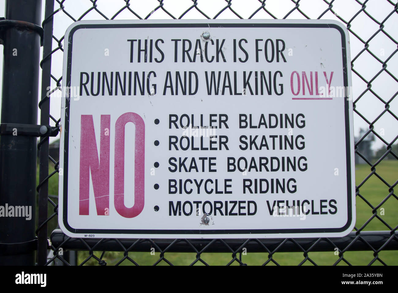 A sign on a fence at a local track reads that the track is for running ...
