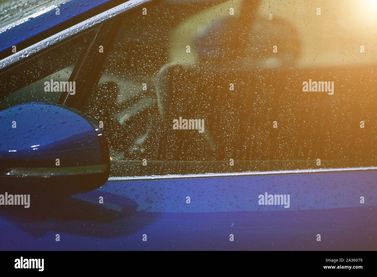 The rain drop on the car. Raindrop close-up on a metallic vehicle panel ...