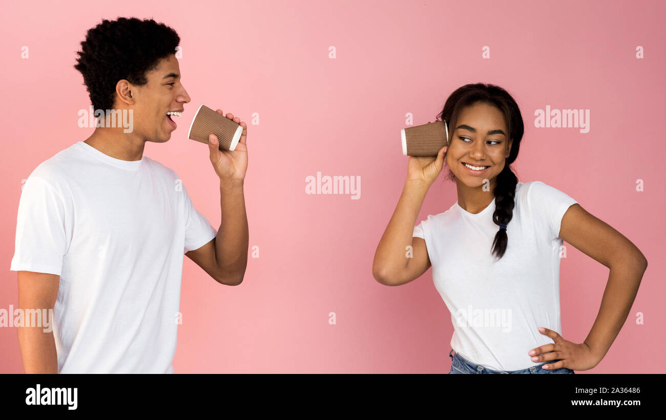 Loving teen couple talking through tin can phone Stock Photo - Alamy