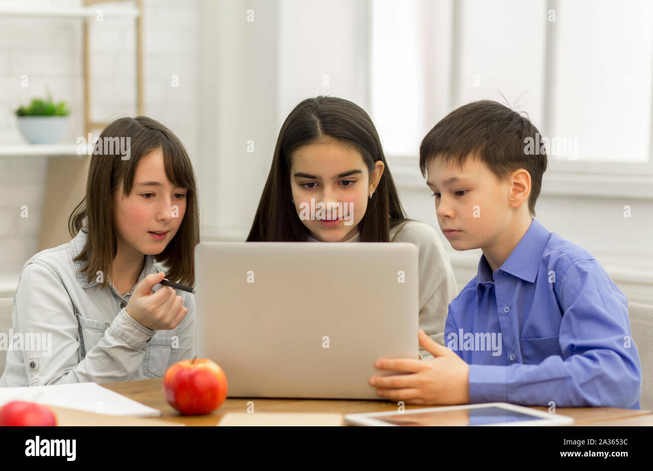 Happy children working on project, using laptop Stock Photo - Alamy