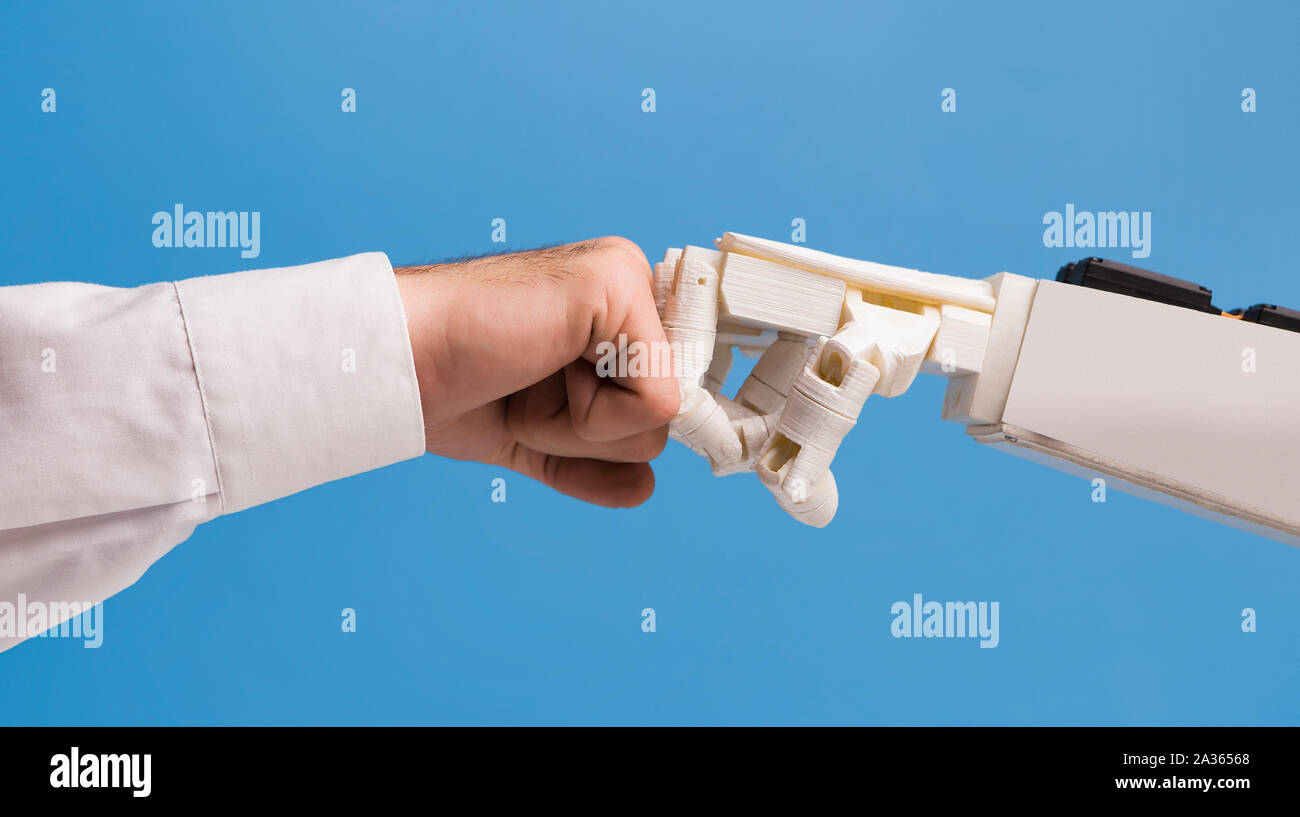 Man and robot punching fists, successful coworking of human and ai ...