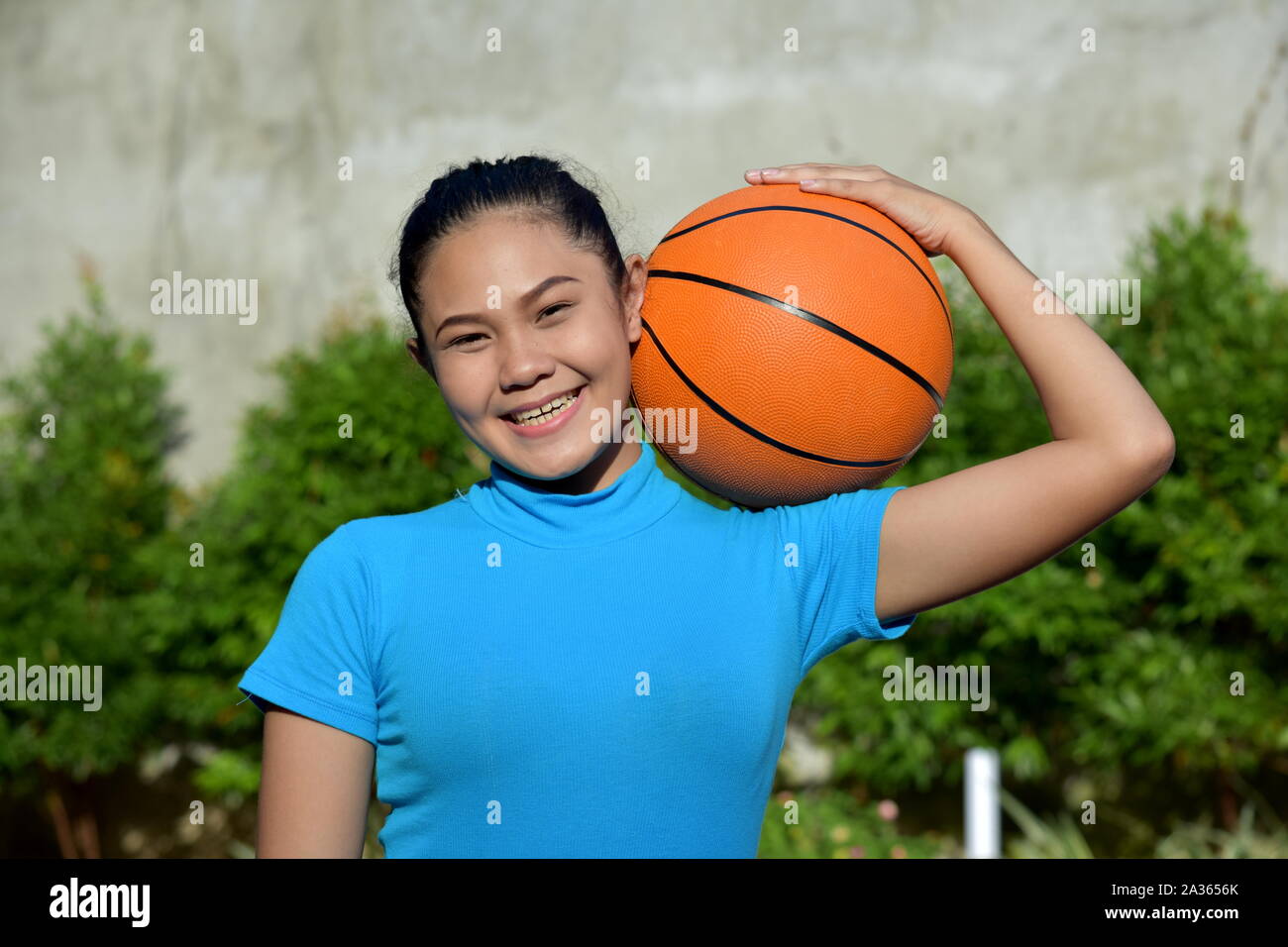 Smiling Sporty Asian Female Basketball Player With Basketball Stock ...