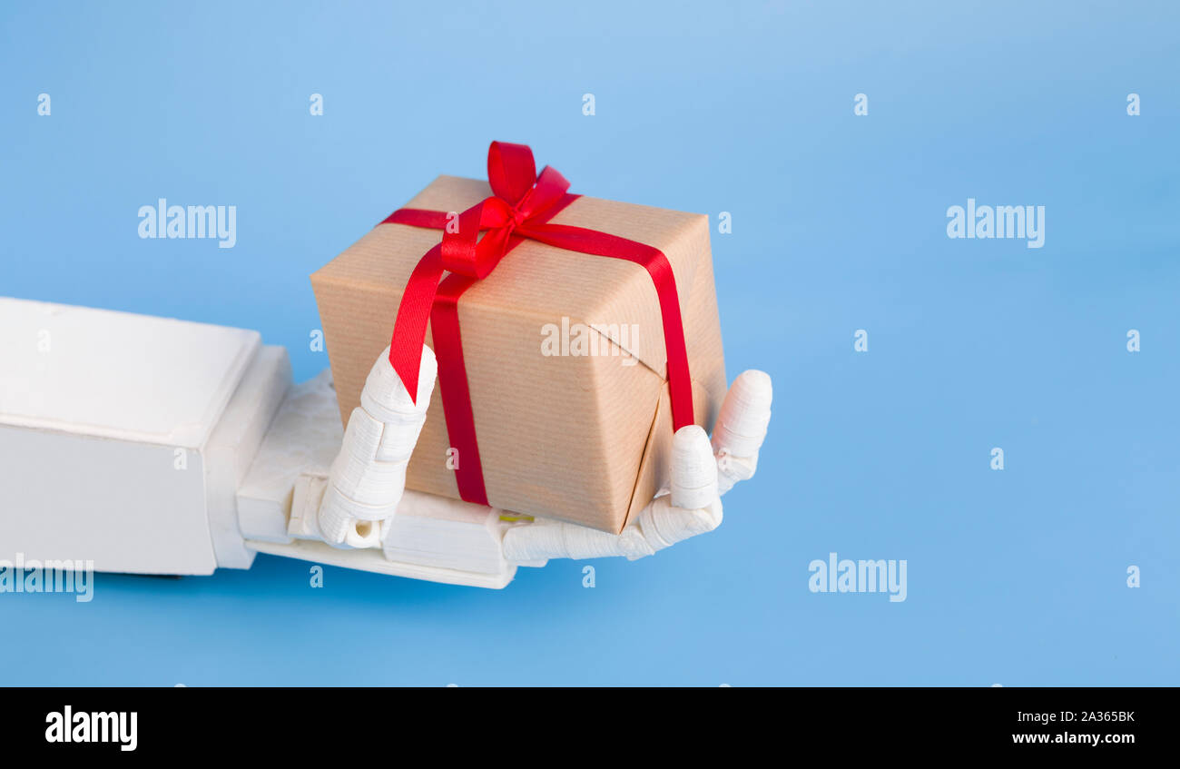 Present box in robotics hand, blue background Stock Photo - Alamy