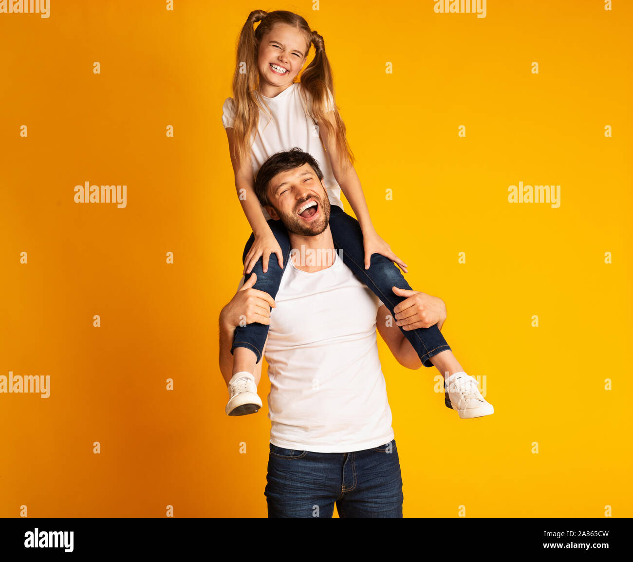 Father Giving Daughter Piggyback Ride Smiling At Camera, Studio Shot ...