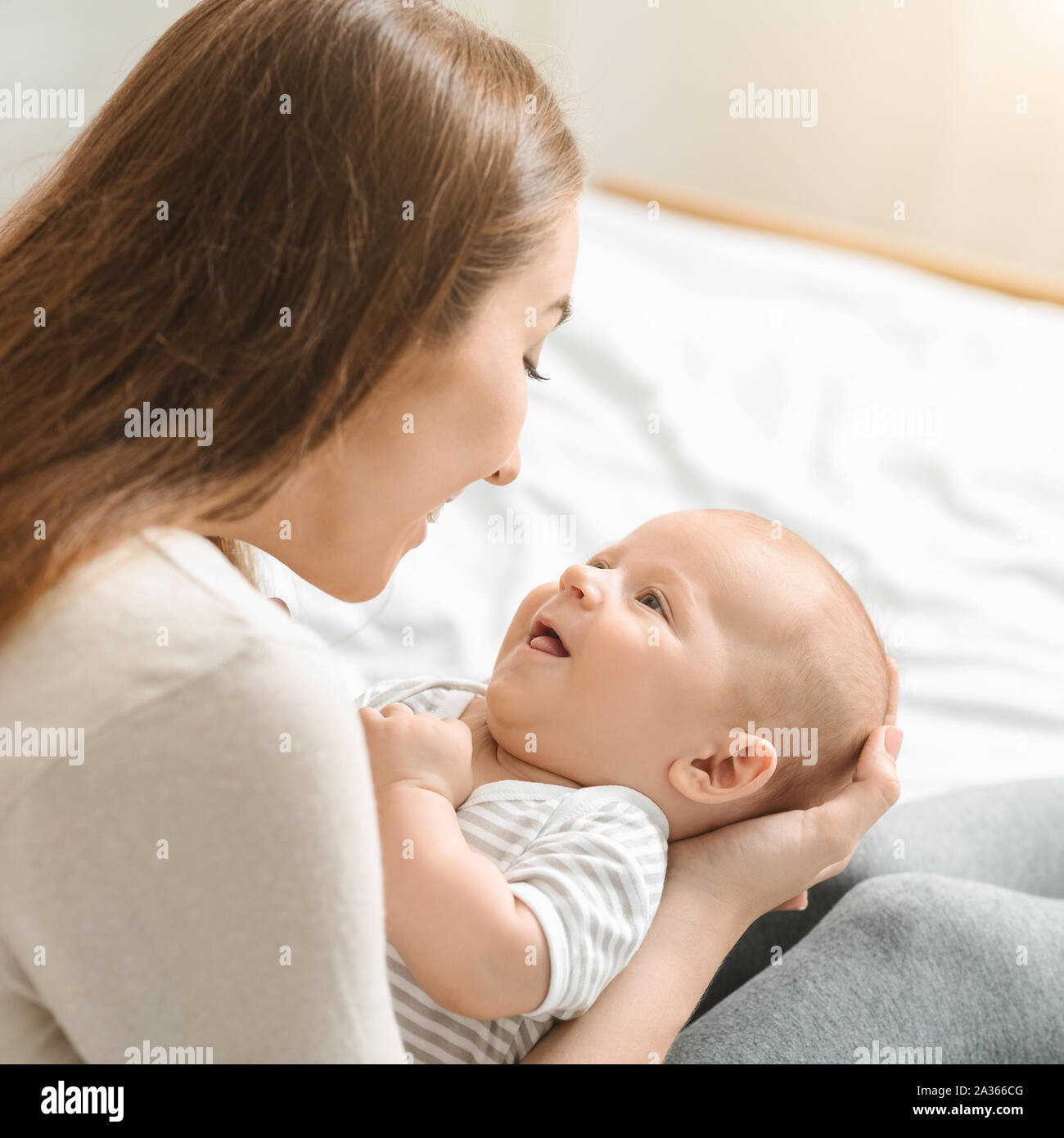Newborn baby lying on mother's laps and looking at her Stock Photo - Alamy