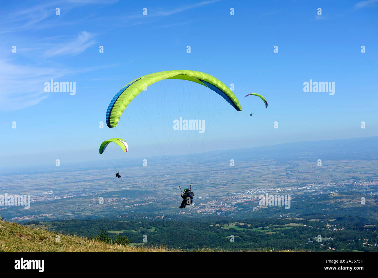 Paragliders in full flight over volcanoes of Puy de Dome in the central ...