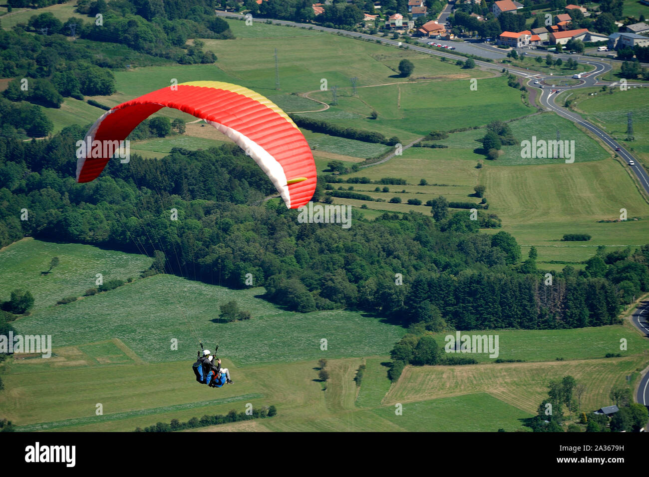 Paragliders in full flight over volcanoes of Puy de Dome in the central ...