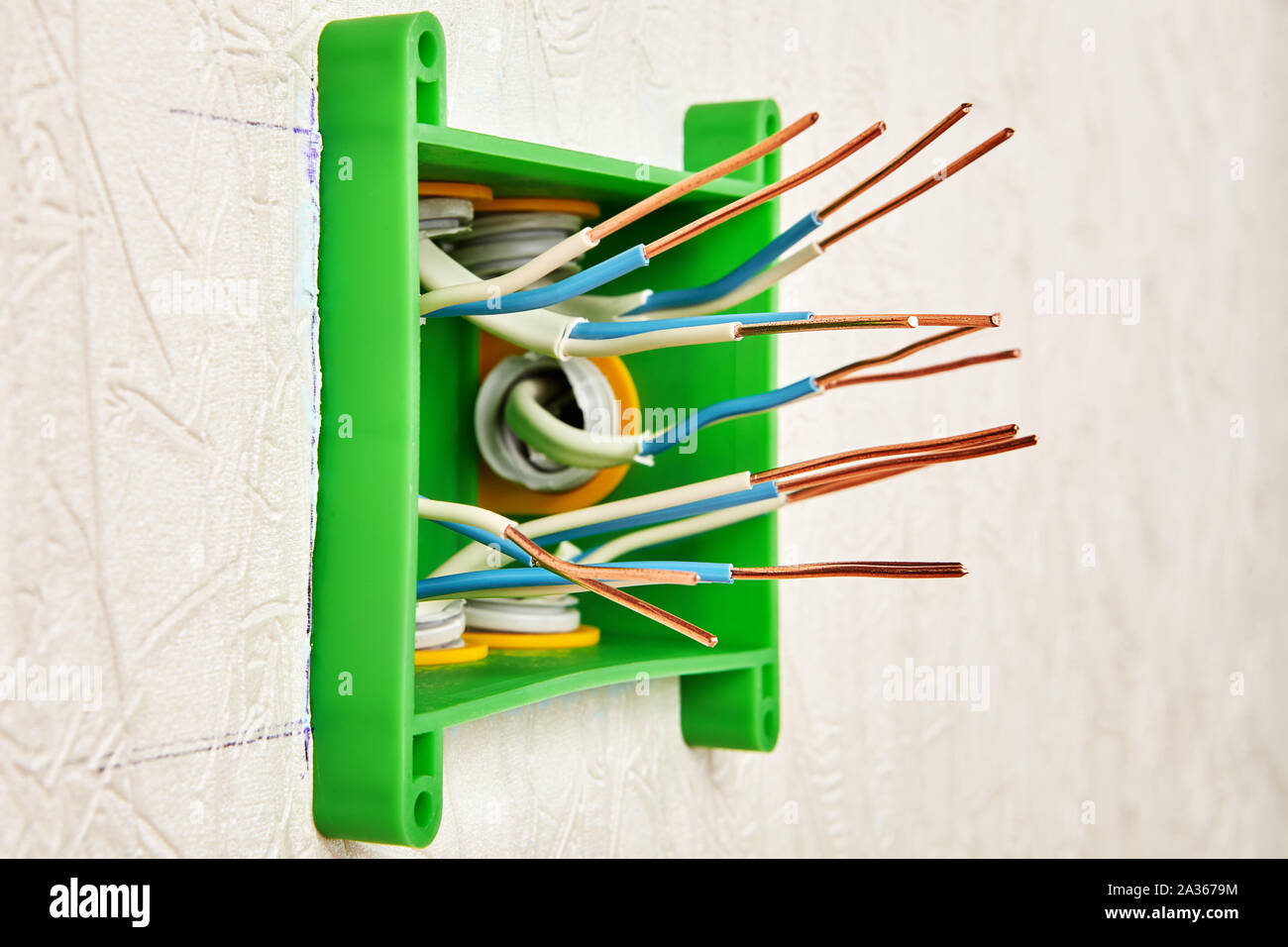 A rectangular plastic junction box at the installation stage, the ends ...
