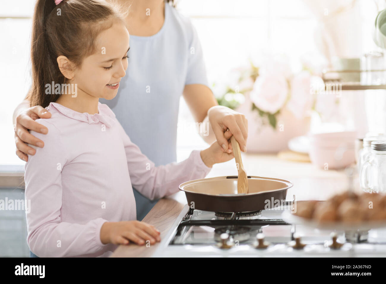 Cute little girl cooking together with mom Stock Photo - Alamy