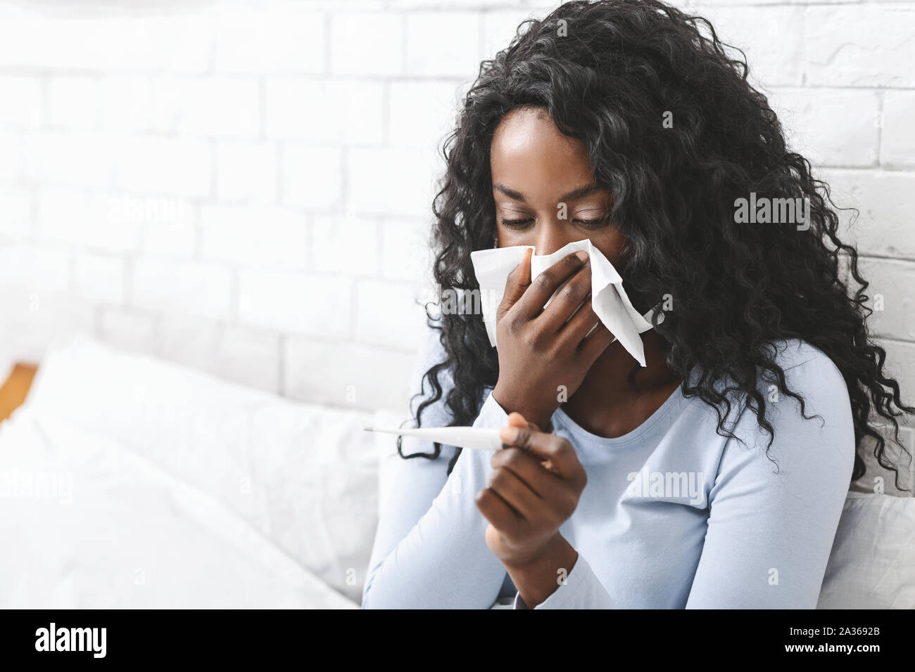 Sick young woman measuring body temperature in bed Stock Photo - Alamy