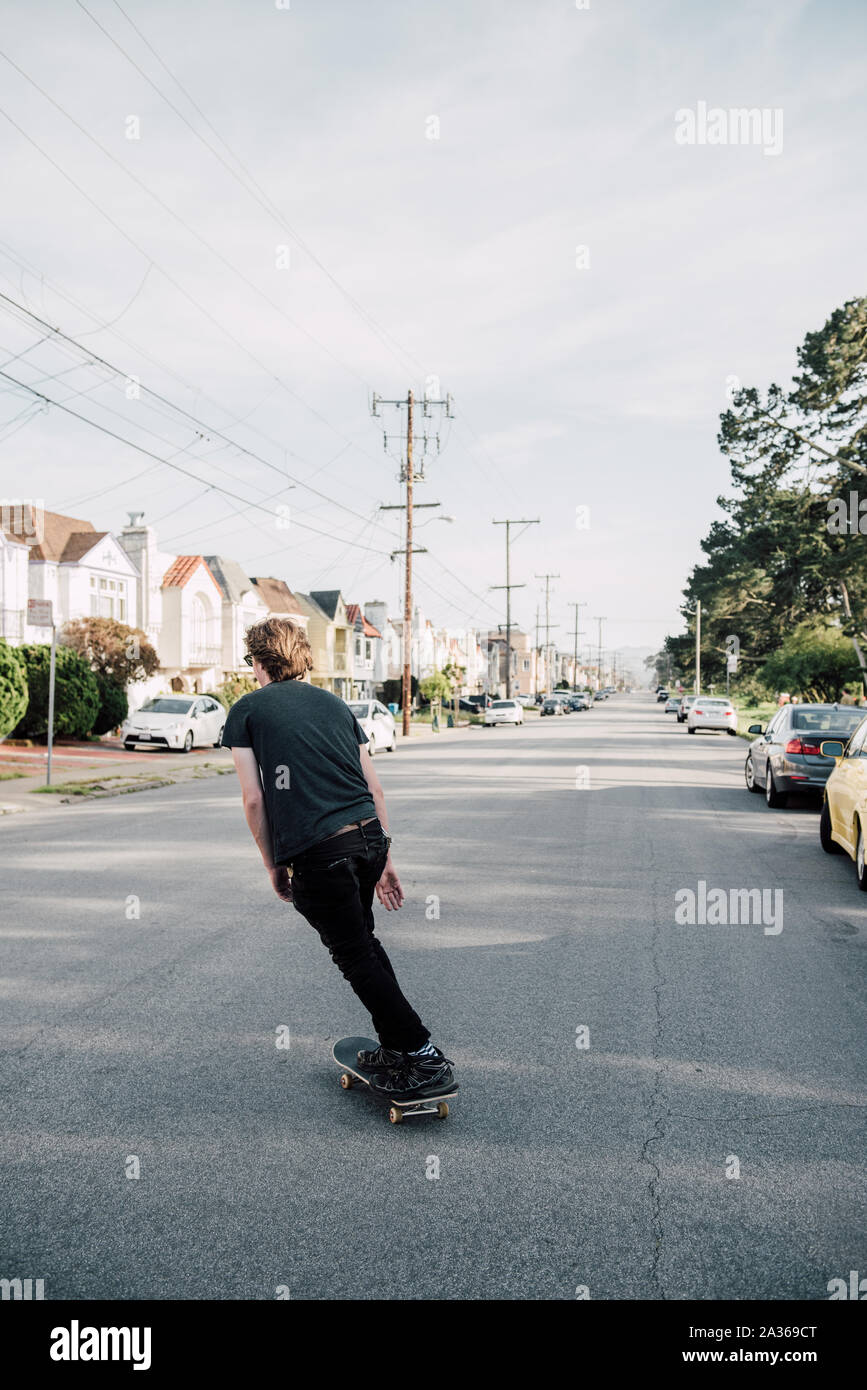 Young Man Skating in the Street in a Residential neighborhood Stock ...