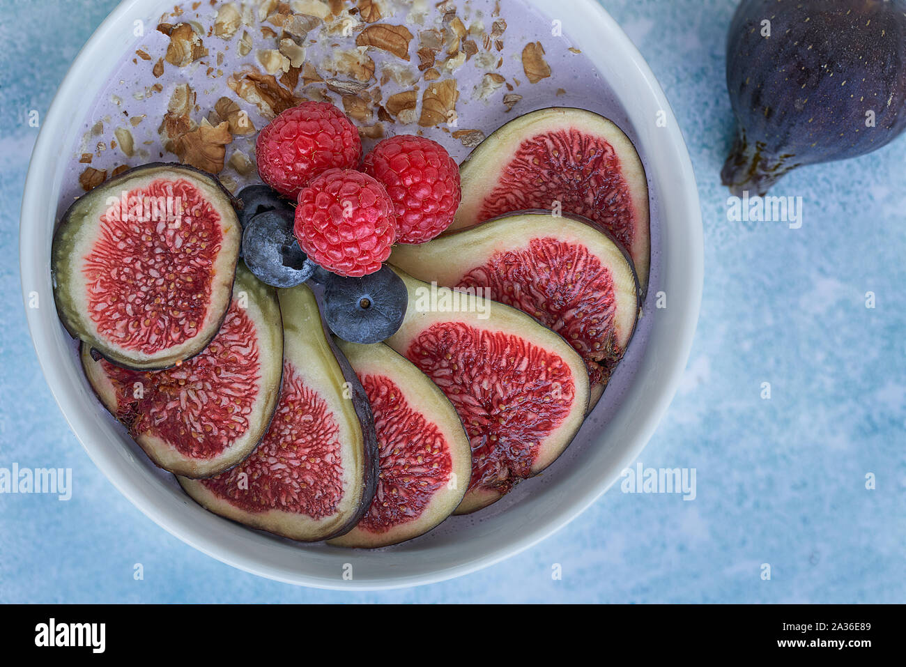 Close-up and top view. Bowl with blueberry mousse, fresh rolled figs ...