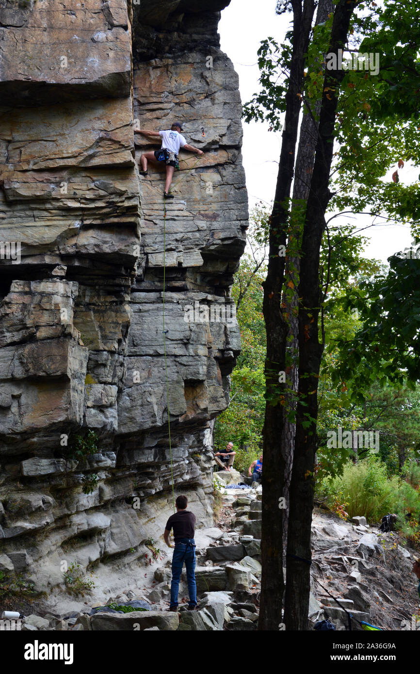 A male climber works his way up the Amphitheater cliff face on the ...