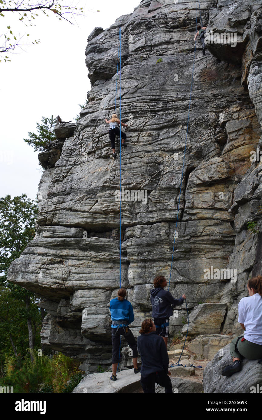 A young female climber works her way up a cliff face on the Ledge ...
