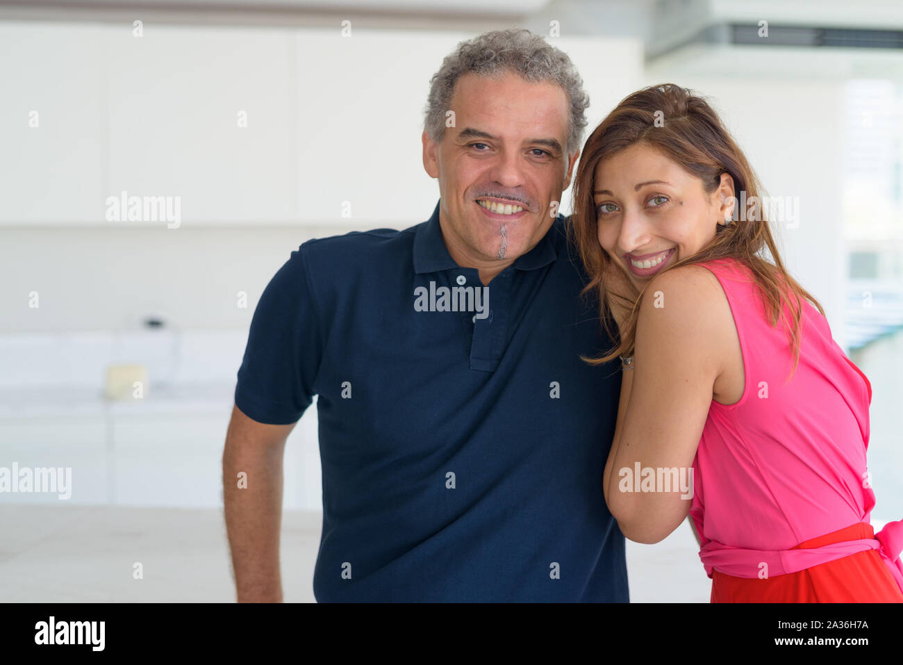 Happy Hispanic married couple smiling together and in love at home ...