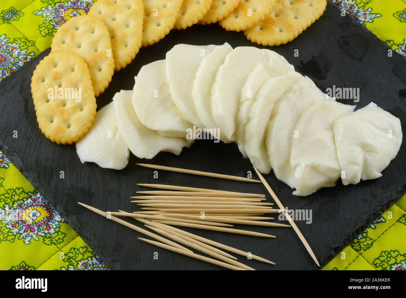 Snack of fresh mozzarella cheese slices and crackers with toothpicks on ...