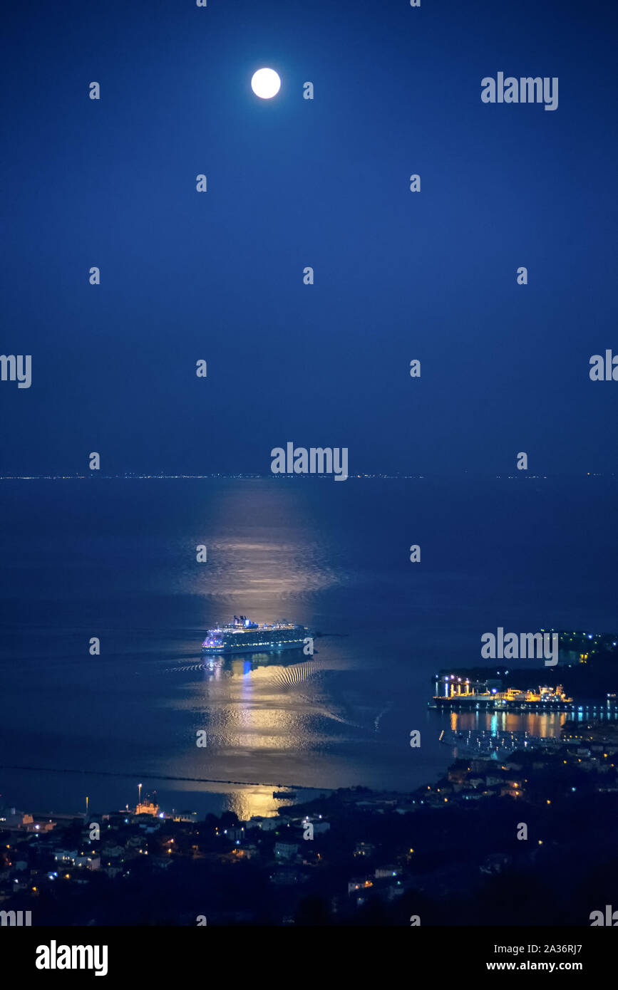 Cruise ship offshore in the path cast by the moon across the ocean at ...