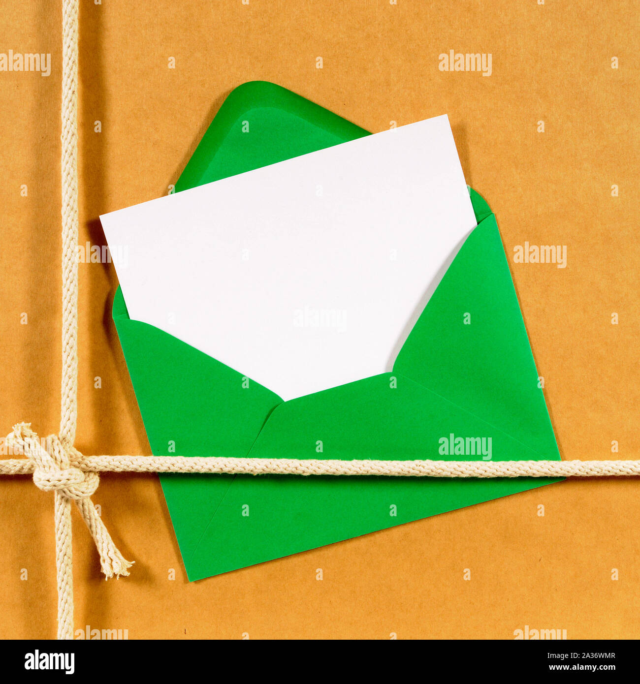 Brown paper parcel with rope and green envelope Stock Photo - Alamy