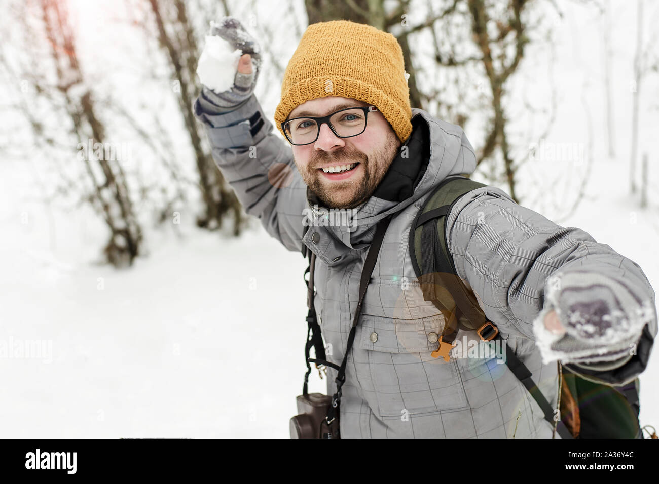 Winter fun. Joyful handsome bearded man in glasses with a camera and a ...