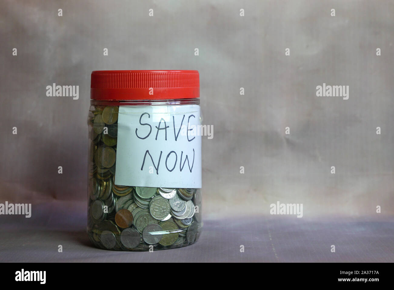 Savings concept. Coins saved inside container with Save Now words ...