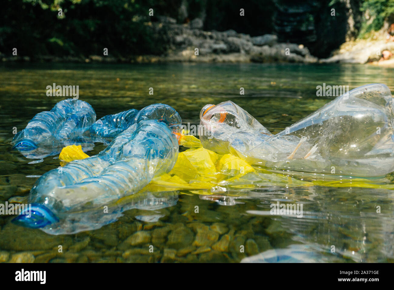 PLASTIC POLLUTION in the river. Dirty plastic bottles and bags on a ...