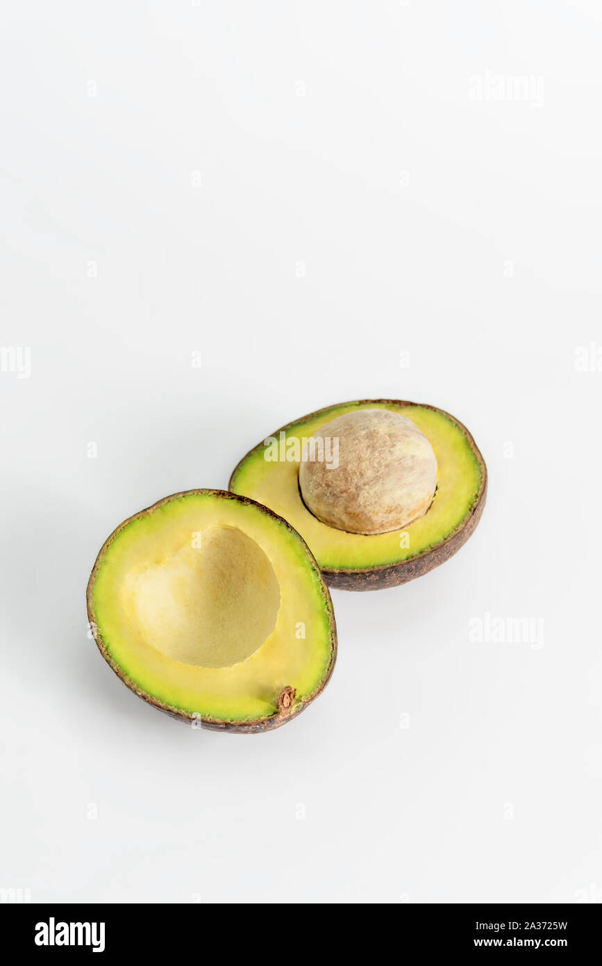 Whole and cut in half avocado fruit on white background Stock Photo - Alamy