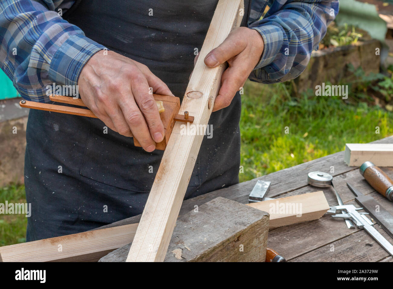 an old carpenter working with wood outdoors during a summer day Stock ...