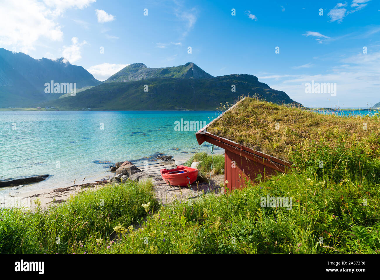 red rowing boat at a beautiful blue fjord on the Lofoten islands in ...