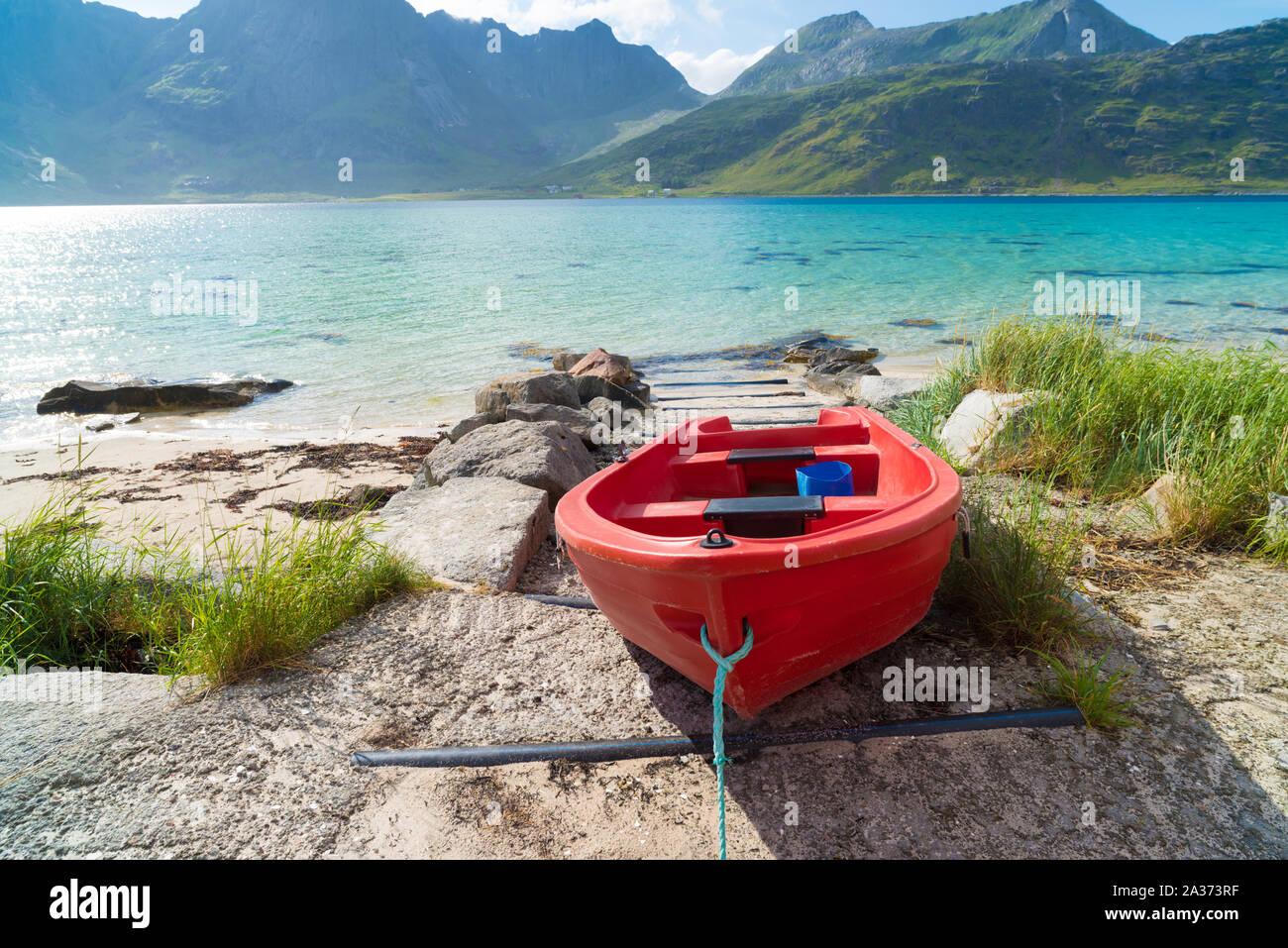 red rowing boat at a beautiful blue fjord on the Lofoten islands in ...