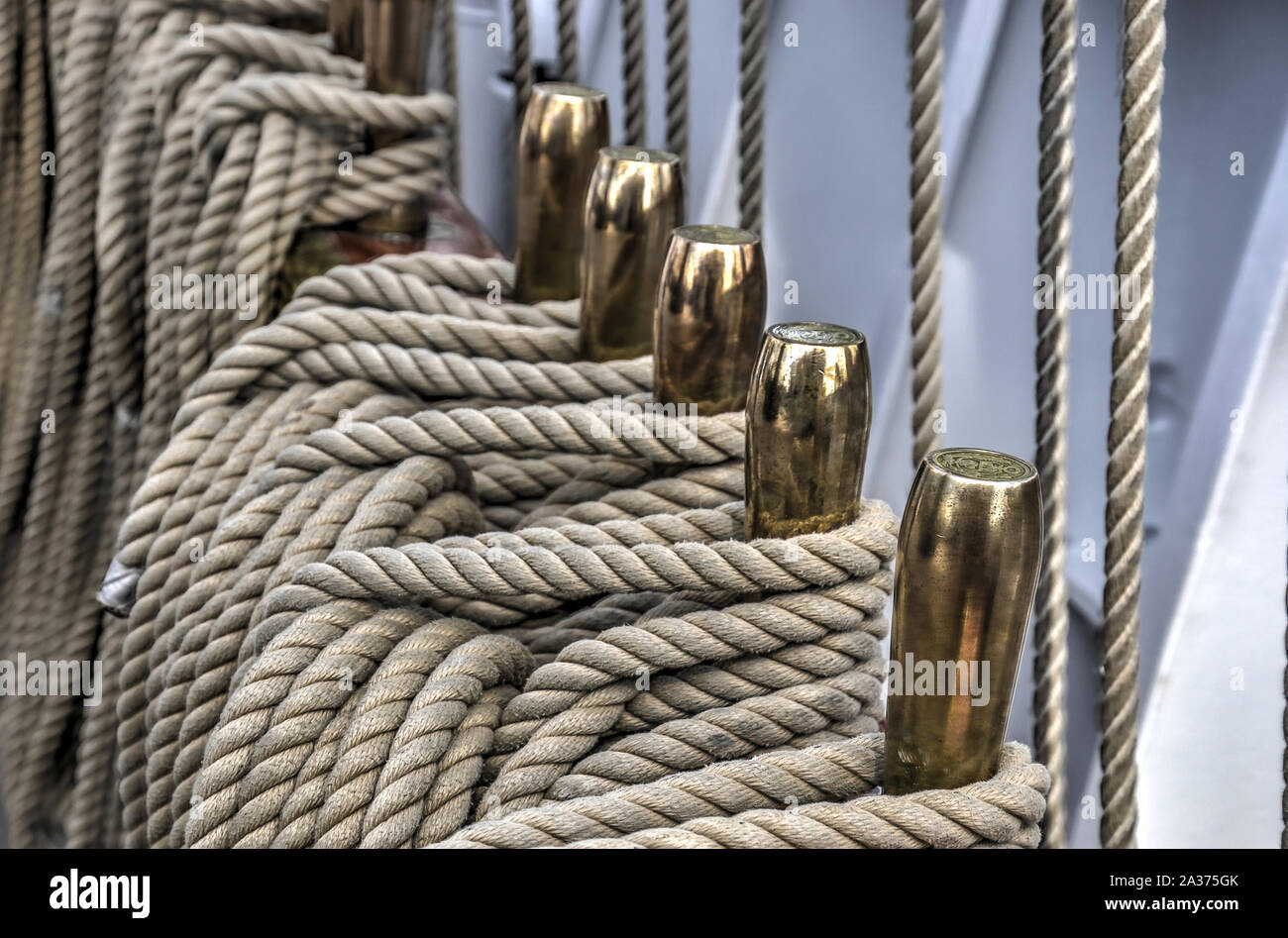 Light grey marine ropes around brass handles on board of a luxury ...