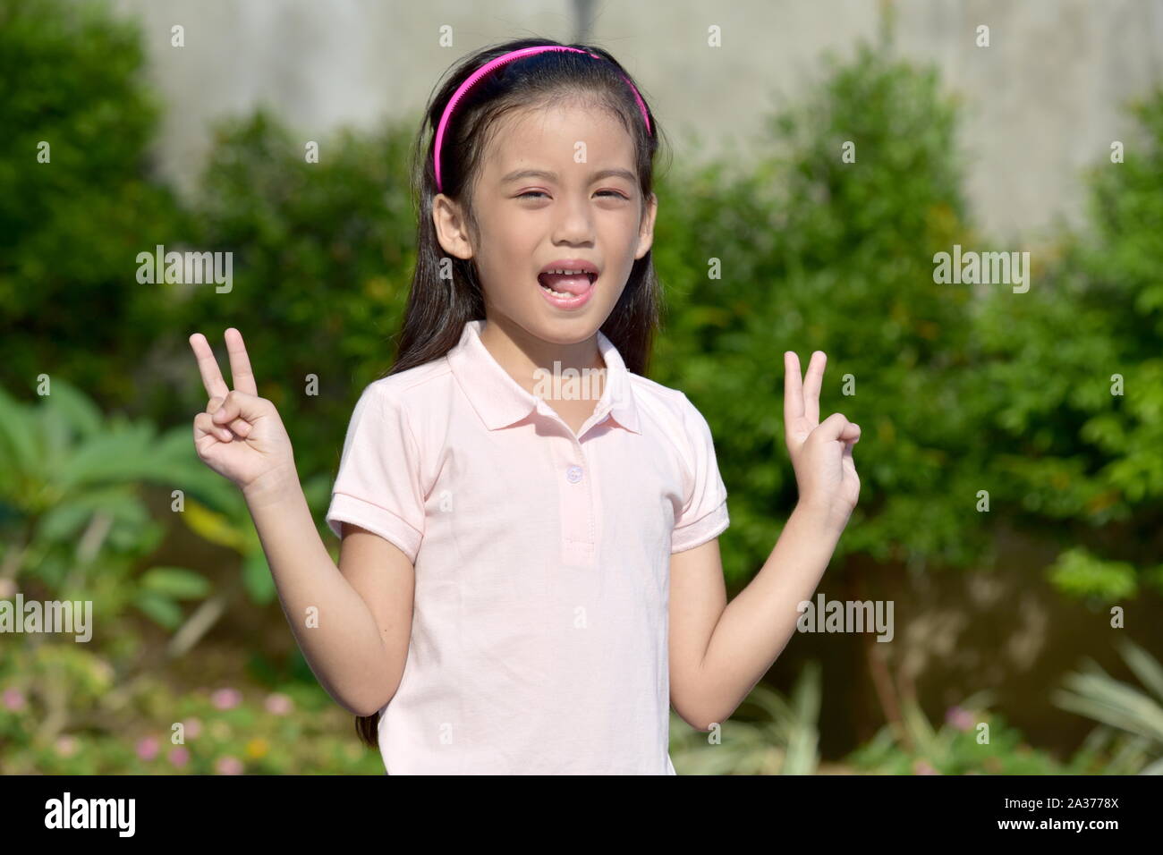 Cute Asian Girl And Peace Sign Stock Photo - Alamy