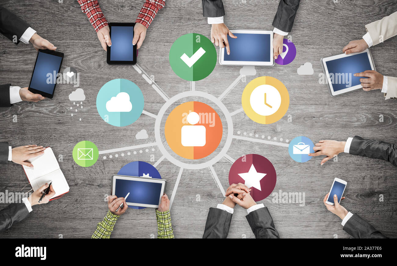 Group of people with devices in hands working together as symbol of ...