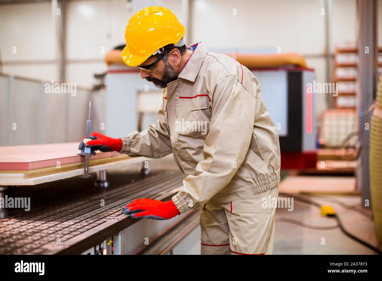 Portrait of senior man operating machine units in modern wooden factory ...