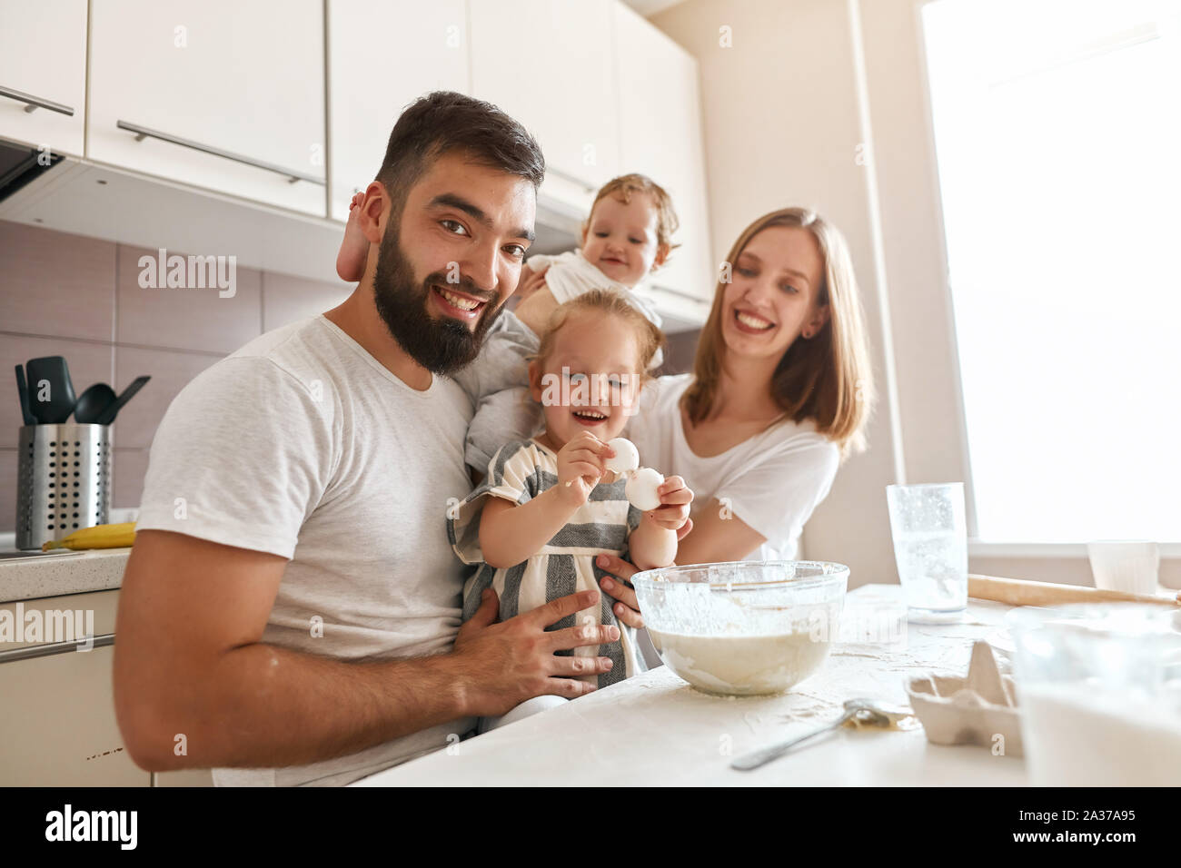 happy young hardworking creative family making up a cake recipe. close ...