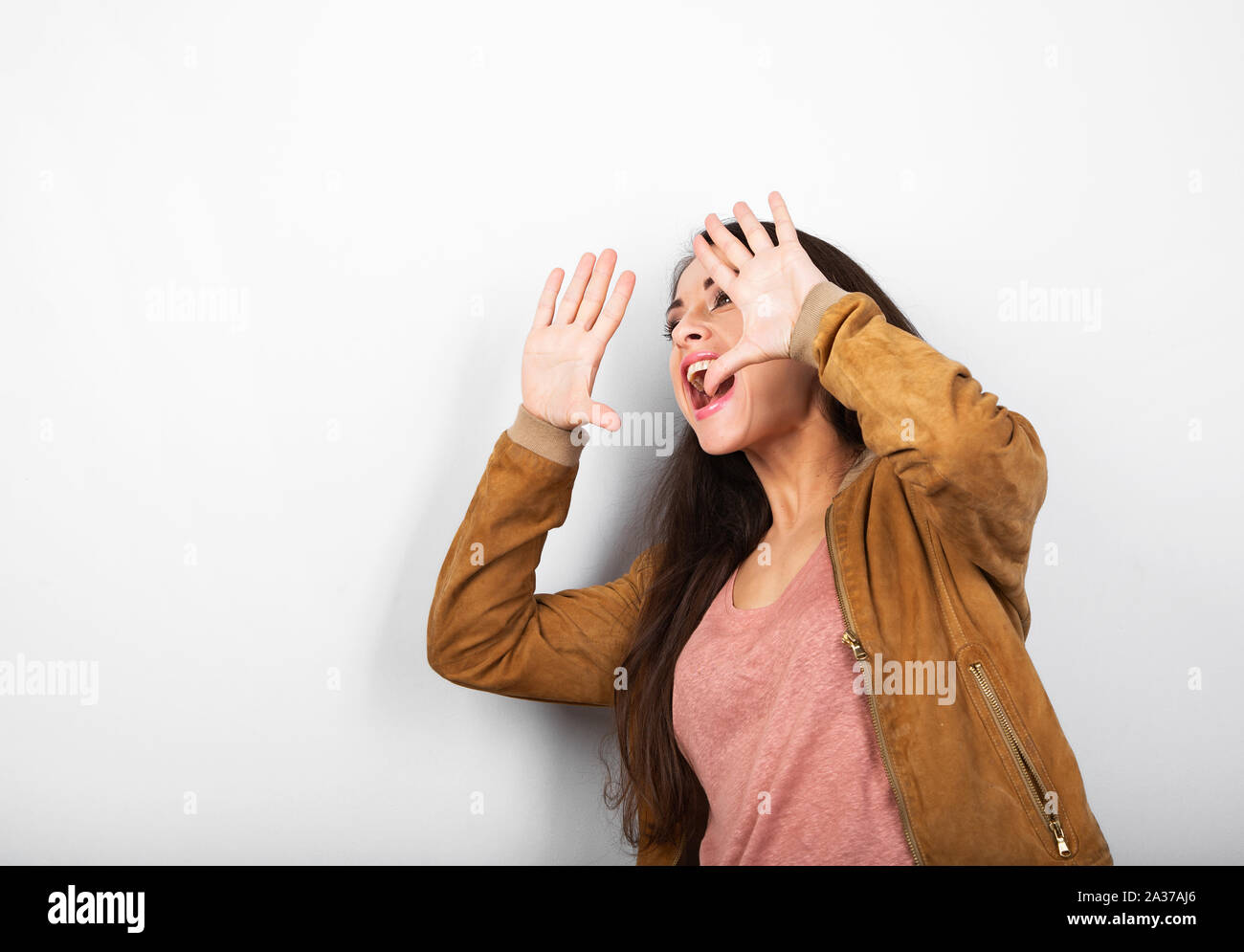Brunette excited woman in yellow jacket shouting and announcing ...