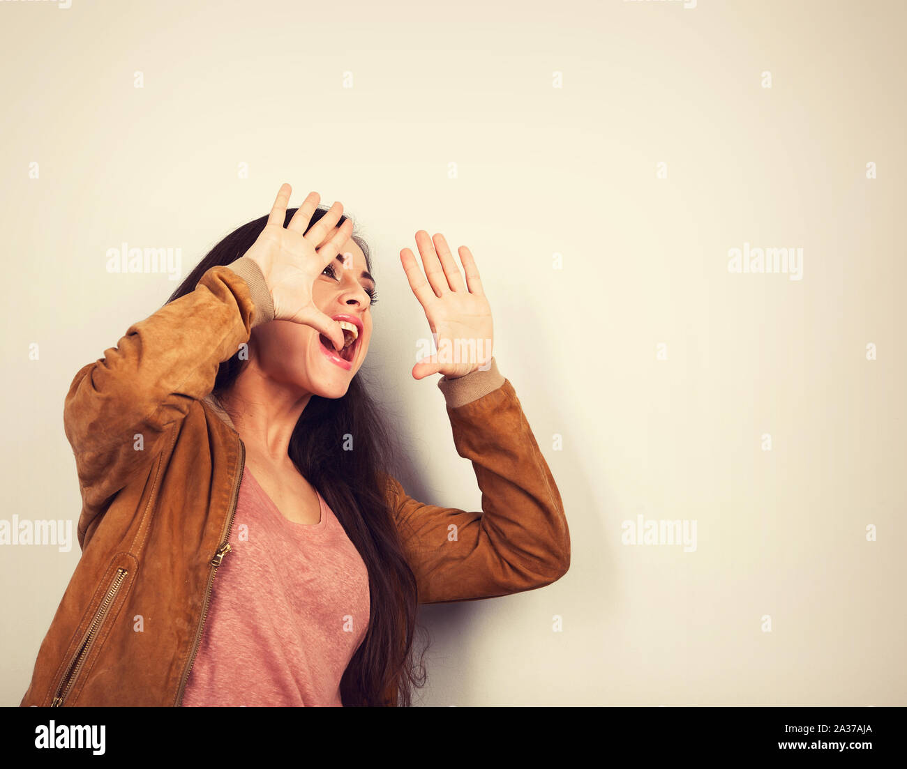 Brunette excited woman in yellow jacket shouting and announcing ...