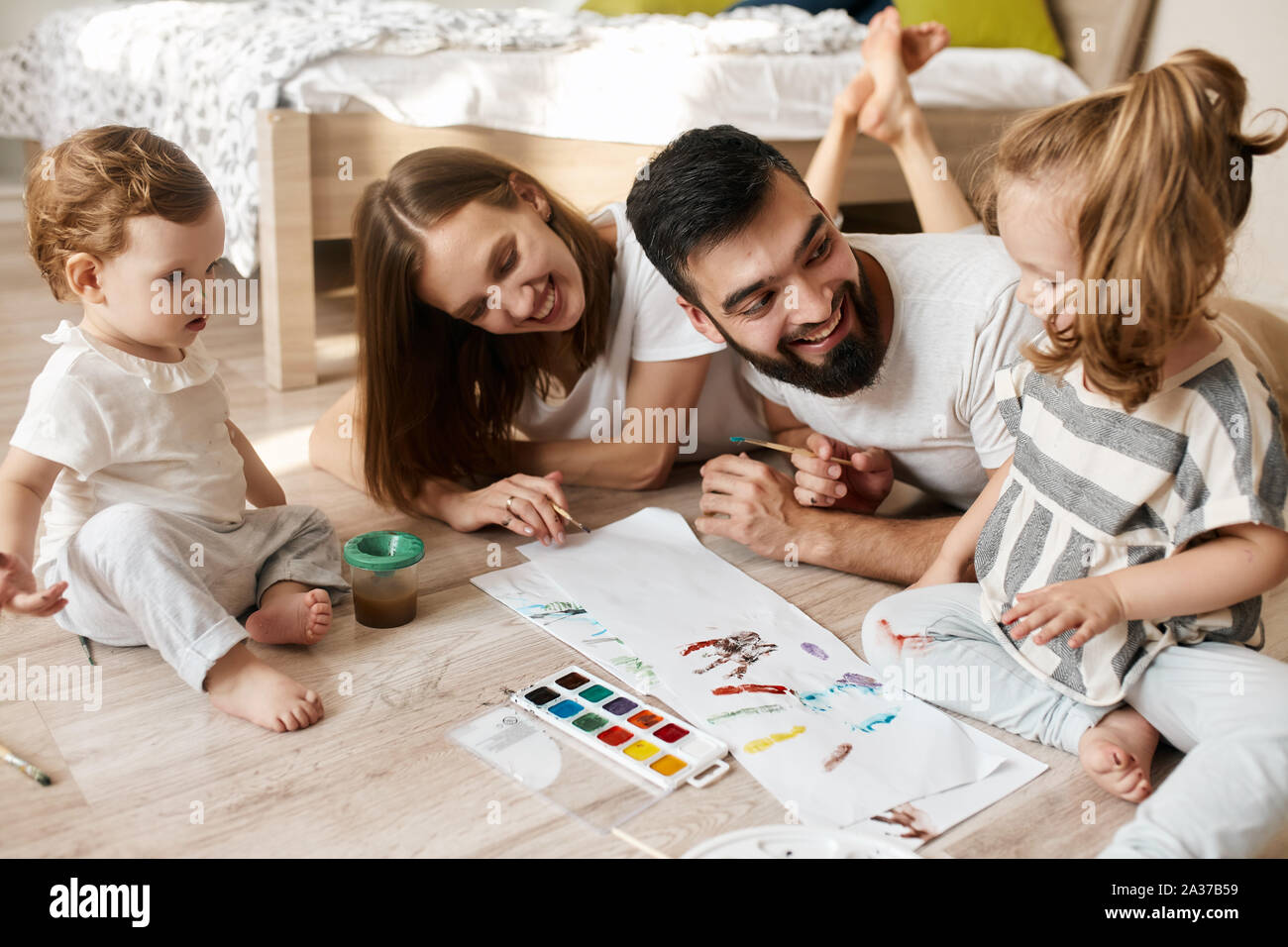 happy parents and their ladorable children making handprints, close up ...