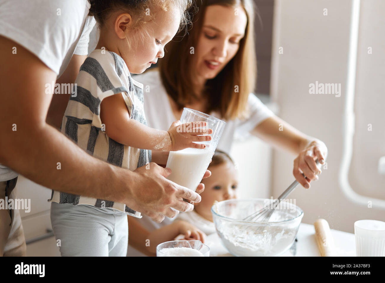 parents and kid preparing cookies in the kitchen, close up side view ...