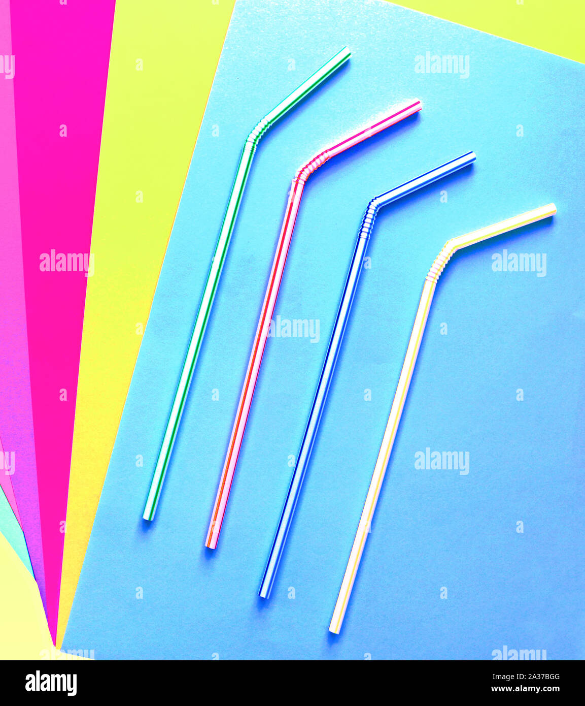 Colour striped plastic cocktail tubes on a mukticolored background ...