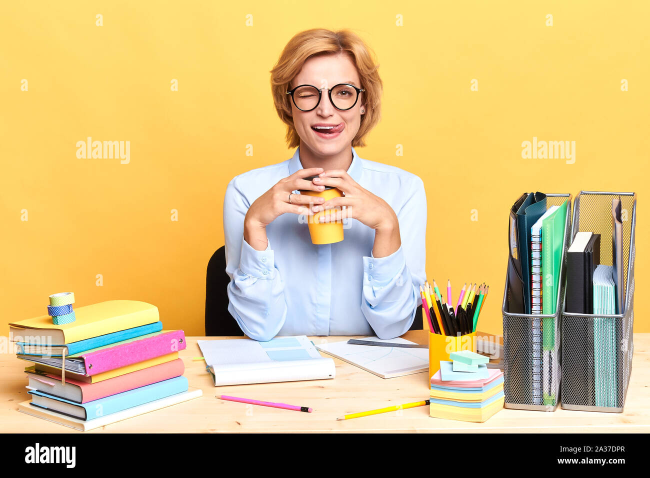 funny young secretary sticking her tongue while drinking coffee ...