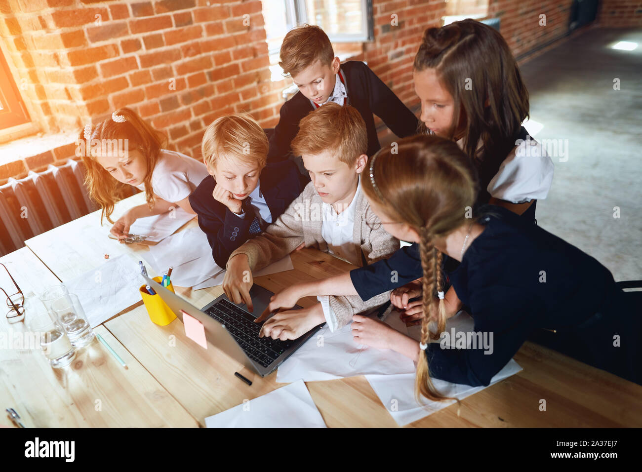 many children preparing project, doing homework indoors, teamwork ...